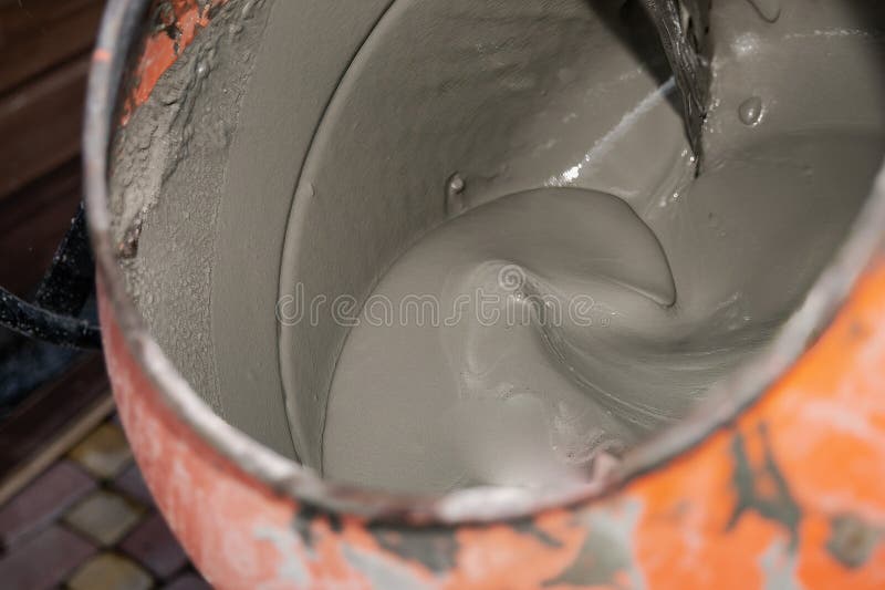 Pouring Wet Concrete from Mixer into Plastic Container at Construction ...