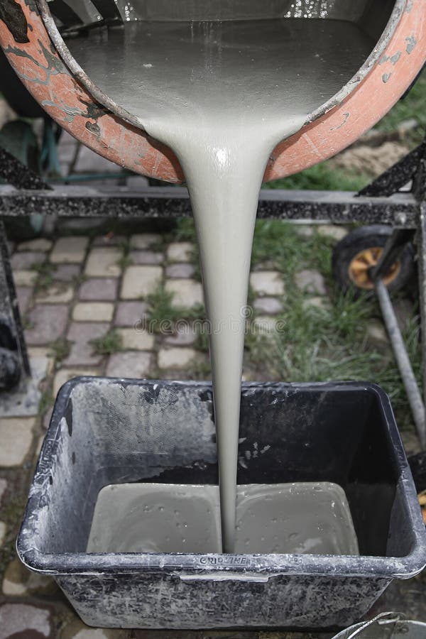 Pouring Wet Concrete from Mixer into Plastic Container at Construction ...