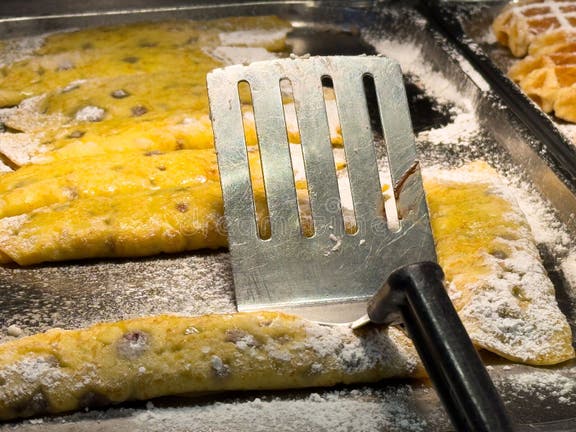 Powdered Sugar-covered Crepes with Spatula on Griddle Stock Photo ...