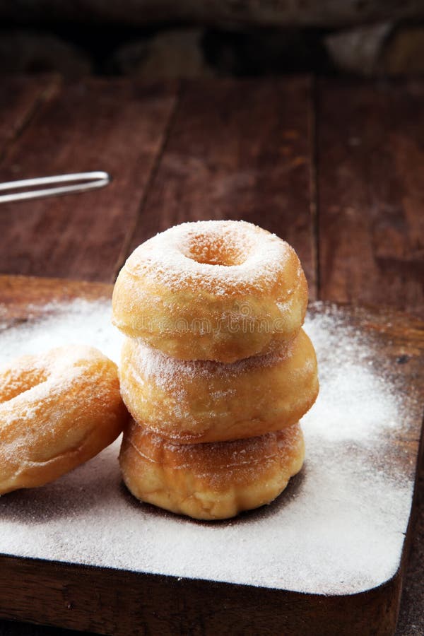 Powdered Sugar Donuts on Rustic Brown Table Stock Photo - Image of ...