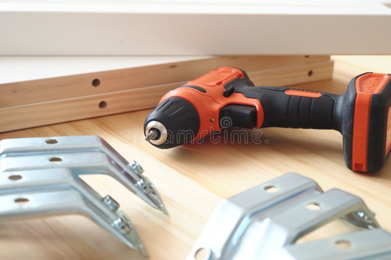 Power Drill and Metal Brackets on Wooden Workspace during Assembly ...
