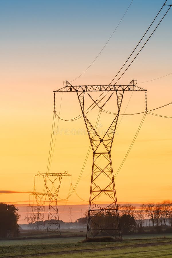Power Line in the Late Evening, High Masts in the Field, Orange Sky ...