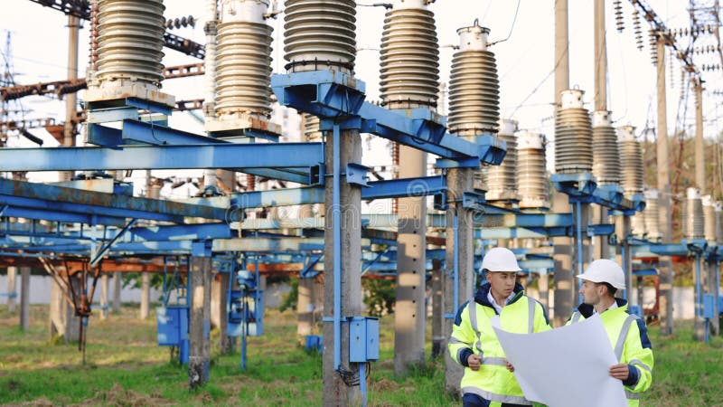 Power Line Workers Working with a Construction Plan on a Sunset ...