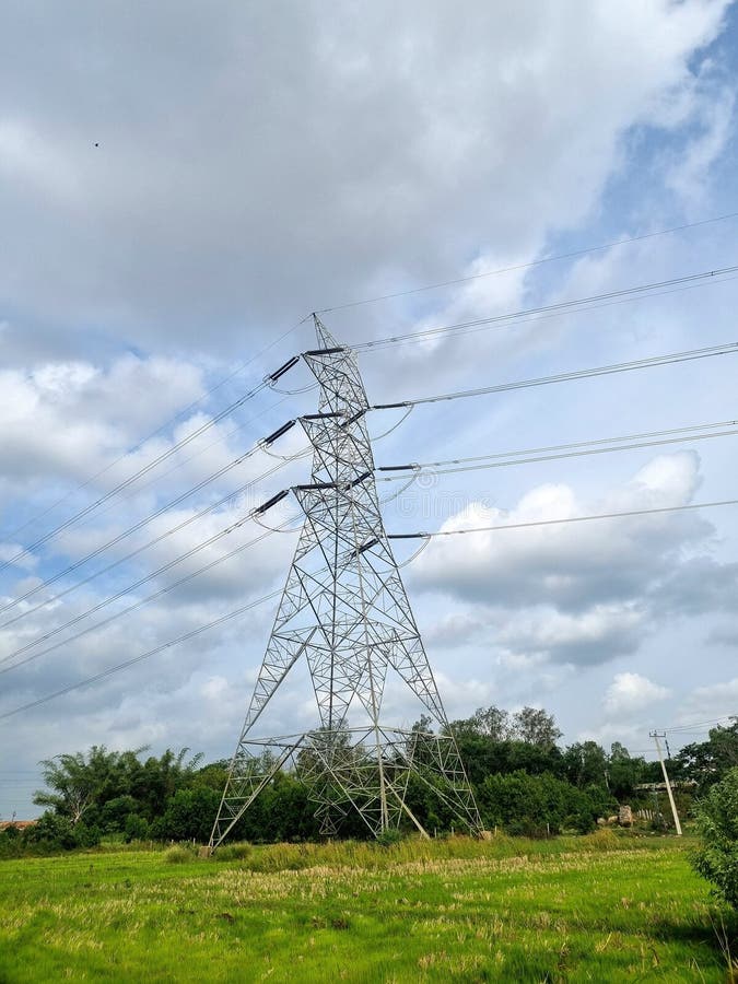 Power Lines Tower in Field Under Clear Blue Sky. Stock Image - Image of ...