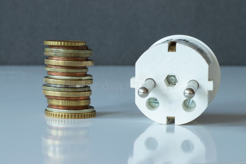 Power Plug and a Stack of Coins Isolated on White Surface with Grey ...