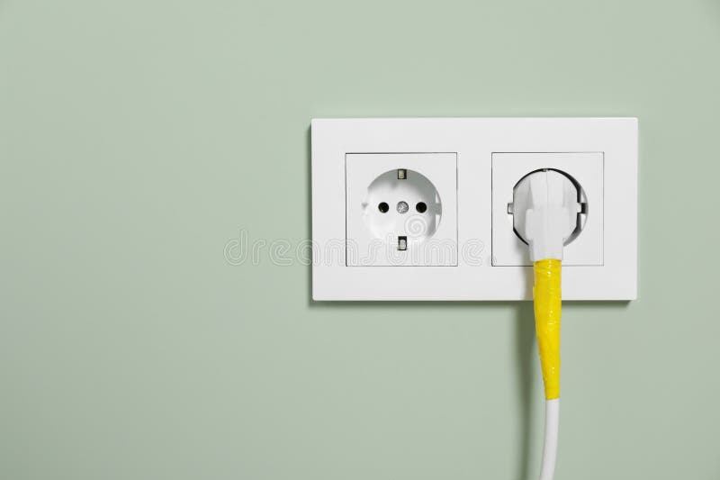 Power Plug with Yellow Adhesive Tape Wrapped Around Wire in Socket on ...