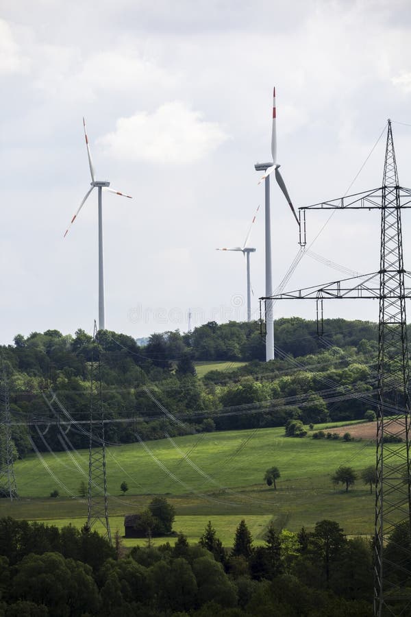 Power Pylon in the Foreground and Behind it a Wind Farm with Wind ...