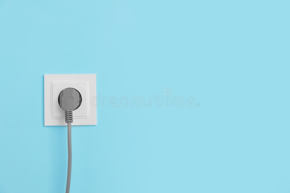 Power Socket with Inserted Plug on Light Blue Wall, Space for Text ...