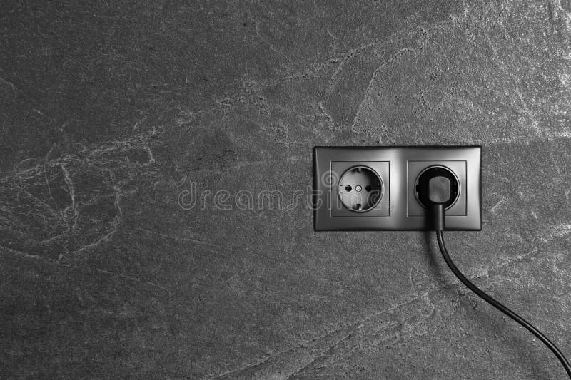 Power Sockets with Inserted Plug on Dark Grey Wall, Space for Text ...