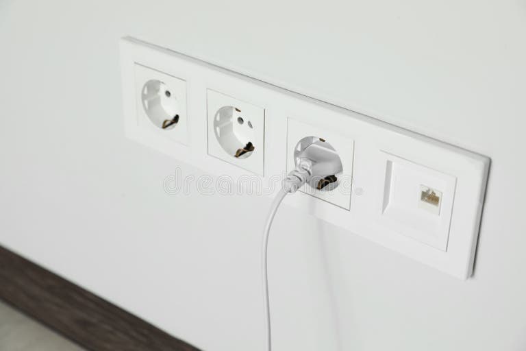 Power Sockets with Inserted Plug on White Wall Indoors, Closeup ...