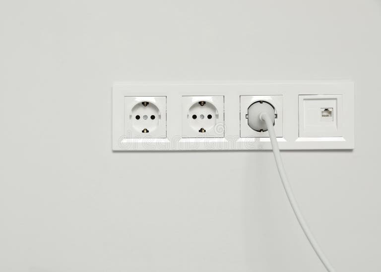 Power Sockets with Inserted Plug on White Wall Indoors. Electrical ...