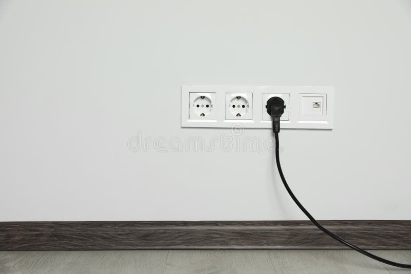 Power Sockets with Inserted Plug on White Wall Indoors, Space for Text ...