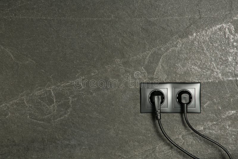 Power Sockets with Inserted Plugs on Dark Grey Wall, Space for Text ...