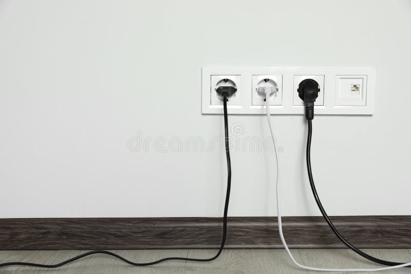 Power Sockets with Inserted Plugs on White Wall Indoors, Space for Text ...