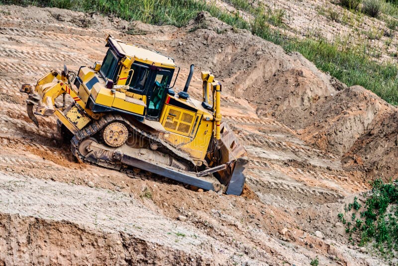 A Powerful Bulldozer in a Sand Pit is Planning a Site. Extraction of ...