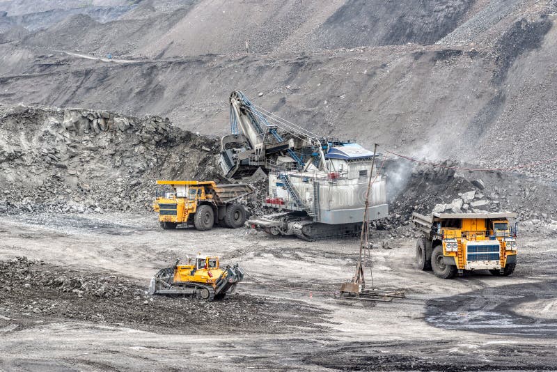 A Powerful Excavator Loads Mining Trucks. Stock Image - Image of site ...