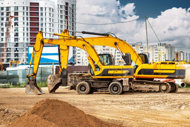 Powerful Excavators at a Construction Site Against a Blue Cloudy Sky ...