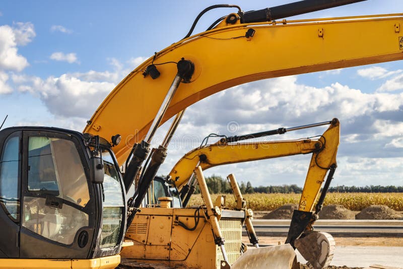 Powerful Excavators at a Construction Site Against a Blue Cloudy Sky ...