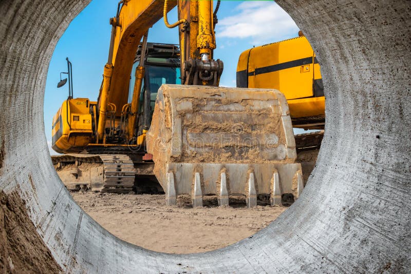 Powerful Excavators at a Construction Site Against a Blue Cloudy Sky ...