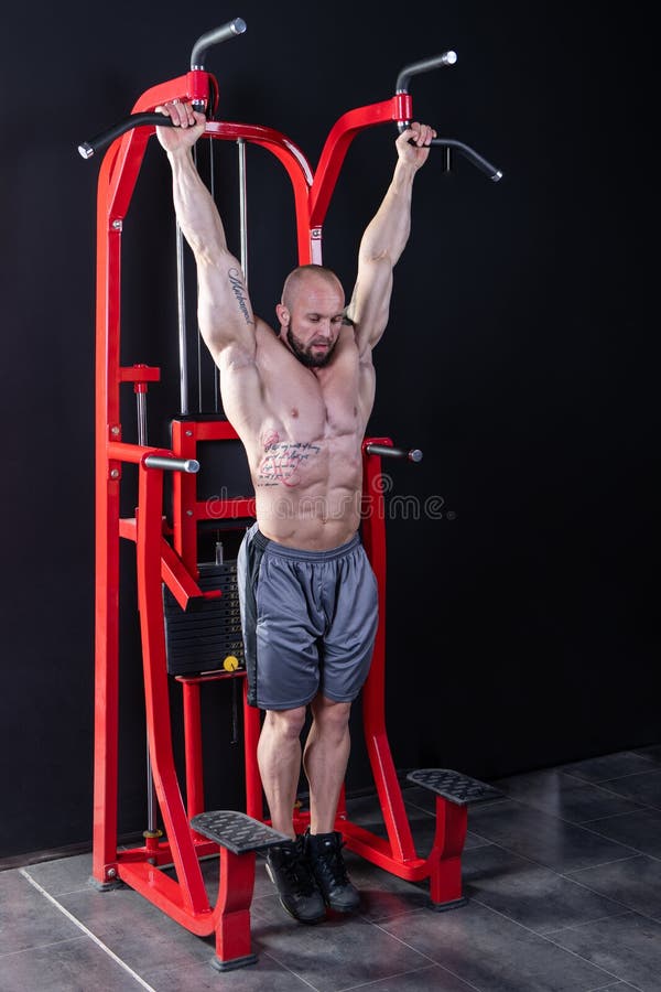 Powerful Muscular Man Doing Abs and Pull Up Exercises on the Machine ...