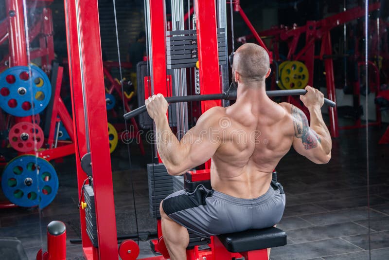 Powerful Muscular Man Doing Exercise for Back on the Lat Machine Stock ...