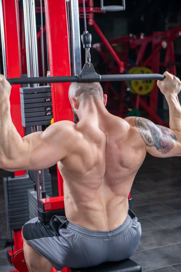 Powerful Muscular Man Doing Exercise for Back on the Lat Machine Stock ...