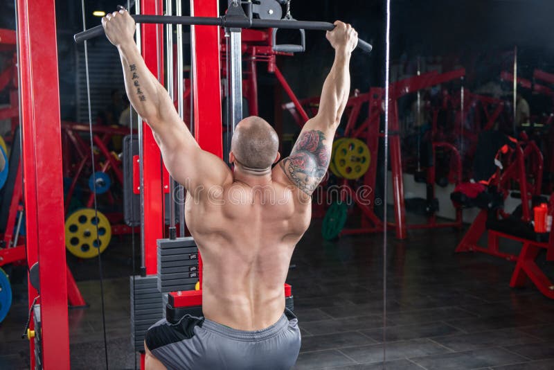 Powerful Muscular Man Doing Exercise for Back on the Lat Machine Stock ...