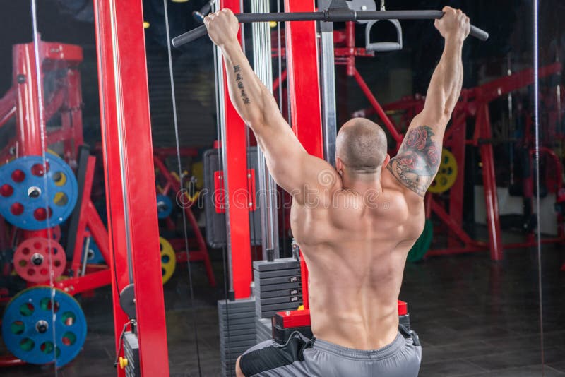 Powerful Muscular Man Doing Exercise for Back on the Lat Machine Stock ...