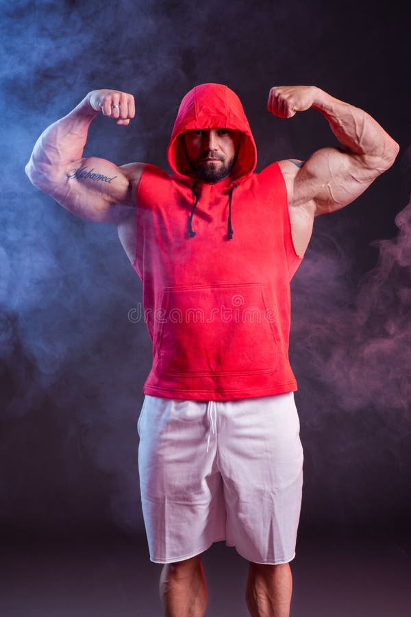 Powerful Muscular Man with a Hood Posing in the Red Sweatshirt. Studio ...