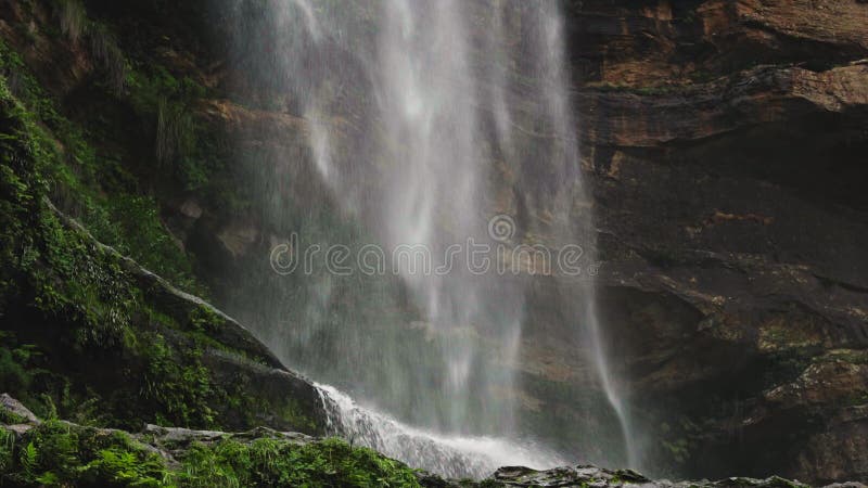 A Powerful Waterfall Cascades Over Rugged Cliffs, Surrounded by Vibrant ...
