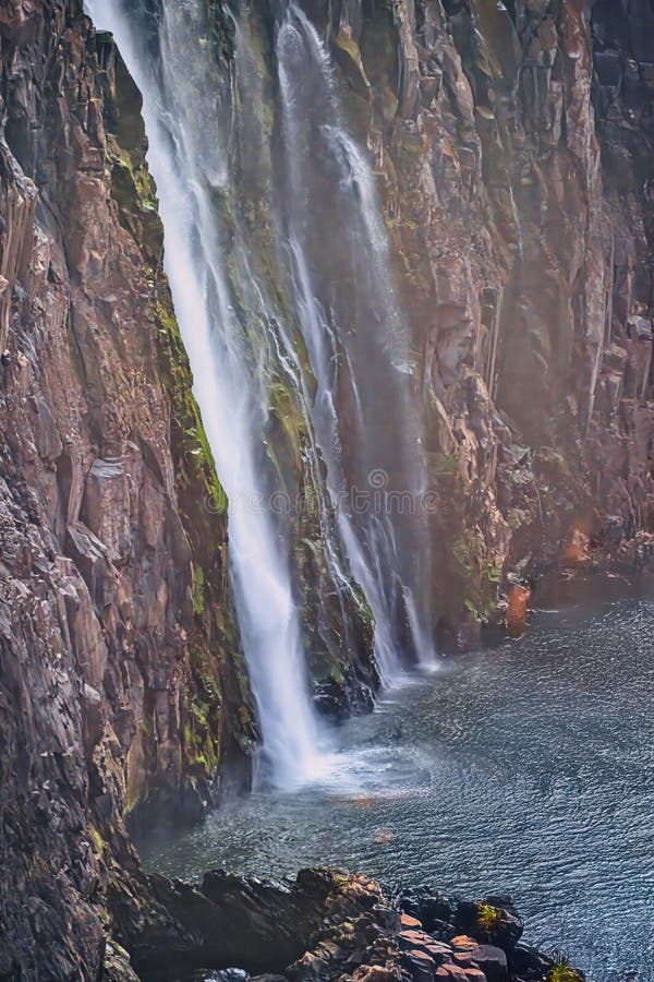 A Powerful Waterfall Crashes into a Calm Pool Below, Creating a ...