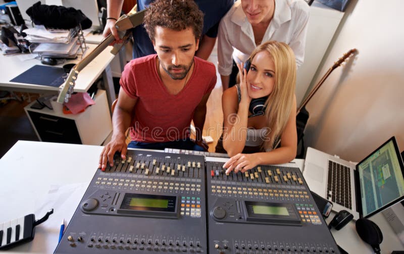 Practicing the Art of Producing. Four Young Music Producers Sitting in ...