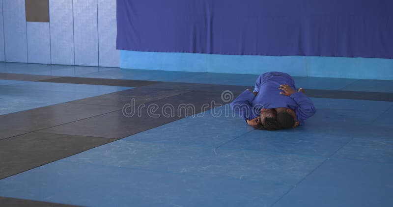 Practicing Judo, Two Athletes Grappling on Blue Mat in Dojo Stock ...