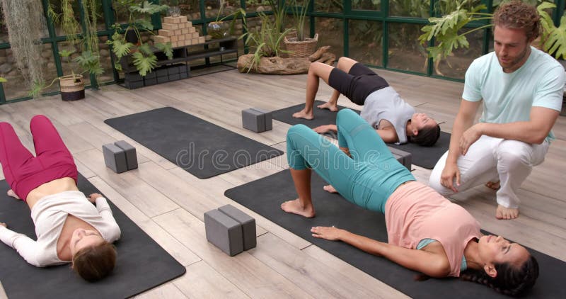 Practicing Yoga, Group Performing Bridge Pose on Mats in Glass House ...
