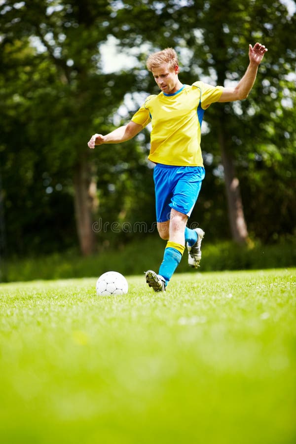 Practising His Technique. a Soccer Player Running Up To Kick the Ball ...