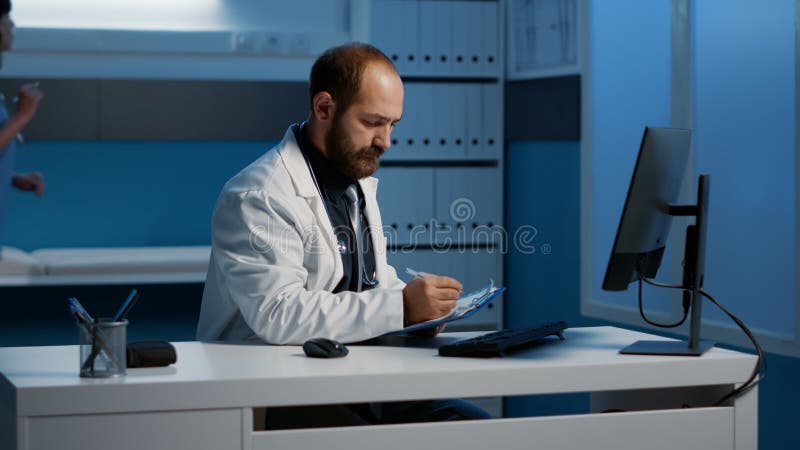 Practitioner Doctor Checking Medical Data on Computer Comparing with ...