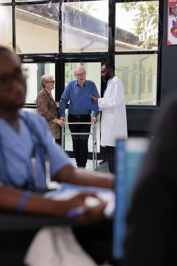 Practitioner Doctor Discussing Illness Symptoms with Injured Elderly ... Practitioner Doctor Discussing Illness Symptoms with Injured Elderly ...