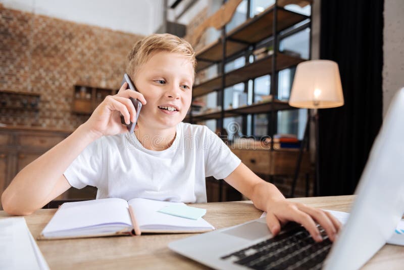Pre-teen Boy Talking on the Phone while Using Laptop Stock Image ...