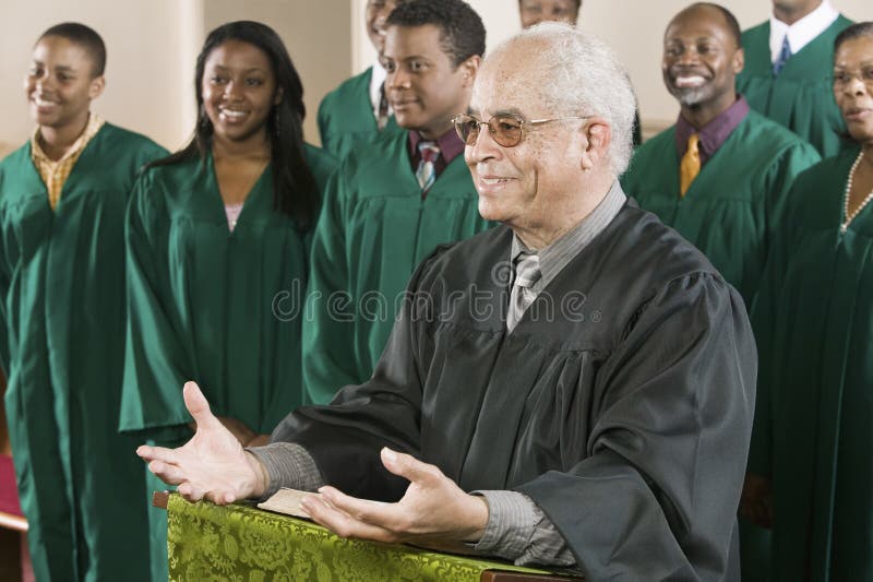 Confident Preacher Standing at Pulpit with Choir in Background Stock ...