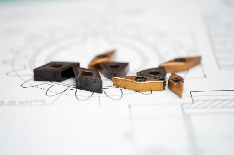 Precision Cutting Tools Arranged on Engineering Blueprints in a Workshop Setting Showcasing ...