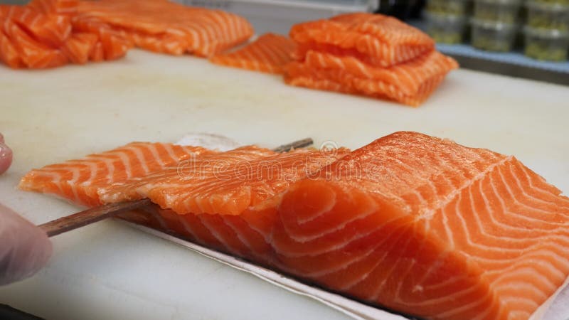 With Precision and Grace the Chef Slices Fresh Salmon into Even Pieces ...