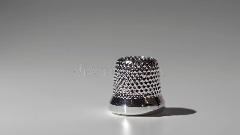 Precision Metallic Thimble Rotating Slowly, Casting Intricate Light and ...