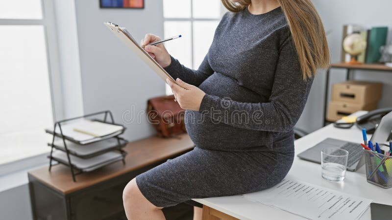 Pregnant Hispanic Woman Taking Notes in an Office Setting, Epitomizing ...