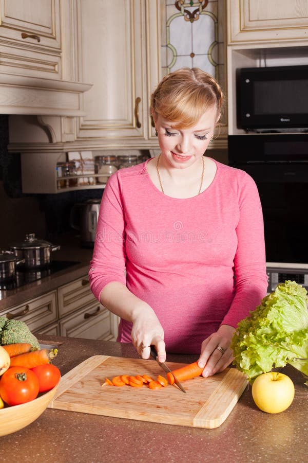 Pregnant woman is cooking stock photo. Image of casual - 64110152