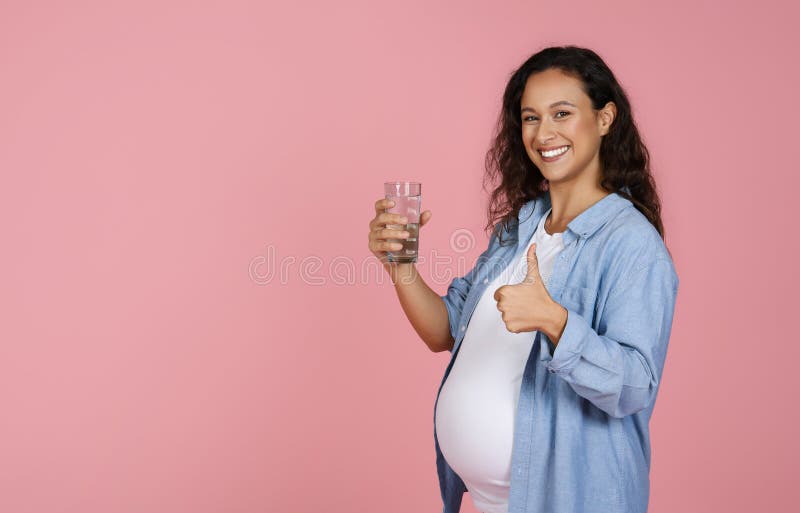 Pregnant Woman Holding A Glass Of Water On The Background Stock Image