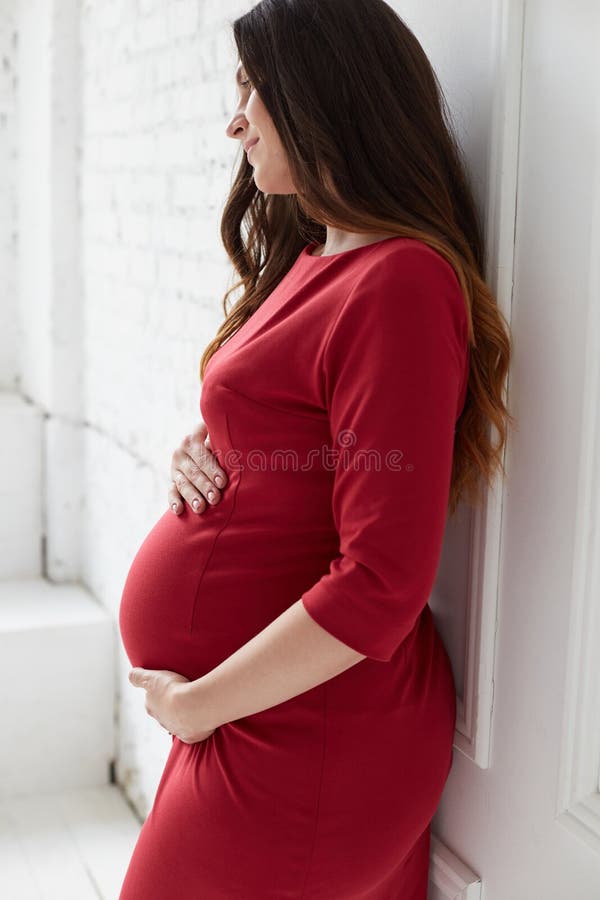 Pregnant Woman In Red Dress Touching Her Belly Pregnancy Concept