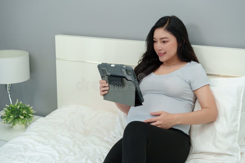 Pregnant Woman Using Digital Tablet on Bed Stock Image - Image of ...