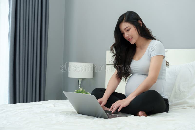 Pregnant Woman Using Laptop Computer on Bed Stock Image - Image of ...