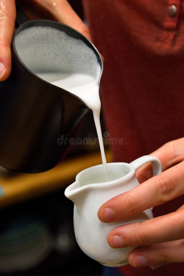 Preparation of Hot Milk for Coffee. Pouring Milk from Container into ...