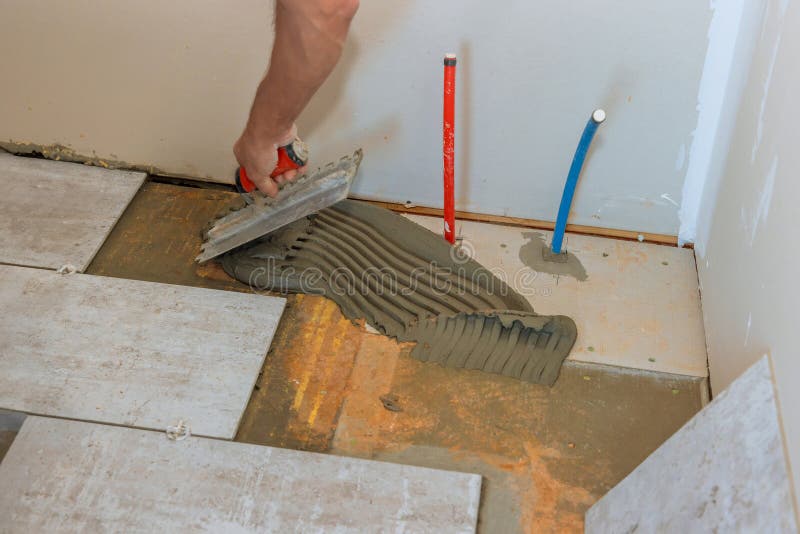 Preparation for Laying Tile on a Concrete Floor by Troweling Adhesive ...